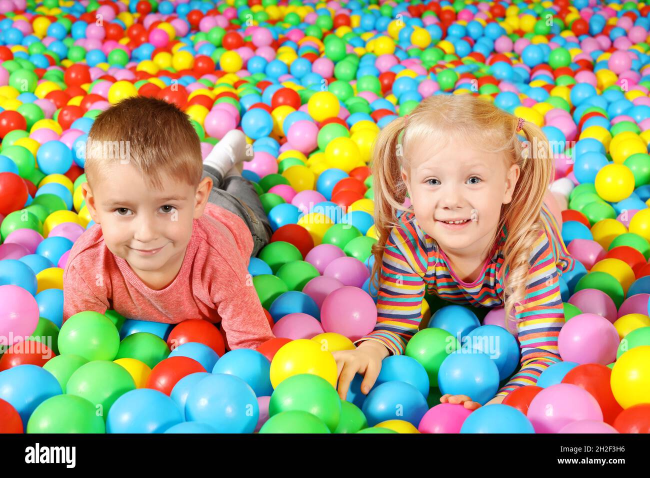 Cute children playing in ball pit indoors Stock Photo - Alamy