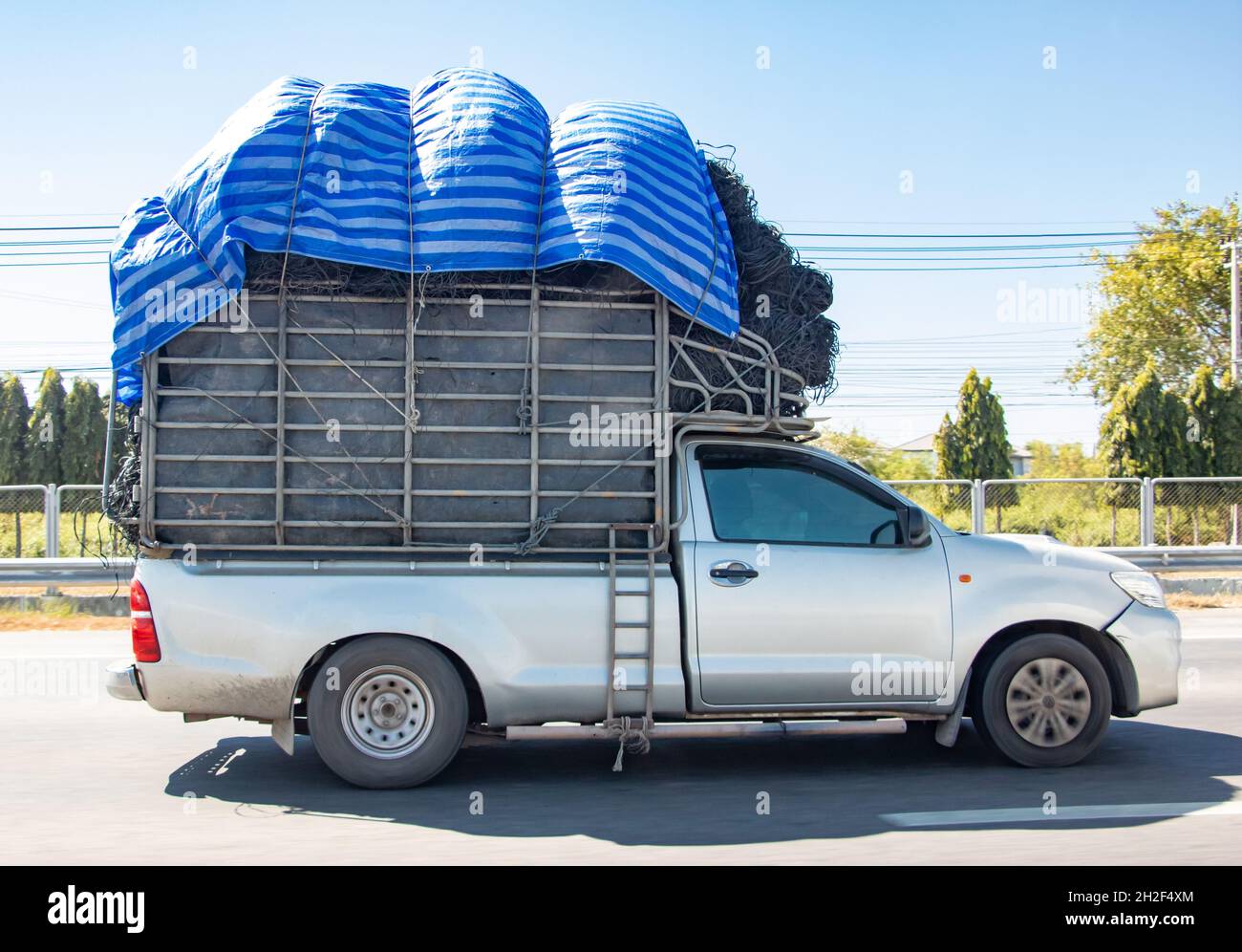 A Pickup carries a heap covered with large canvas, Thailand Stock Photo ...