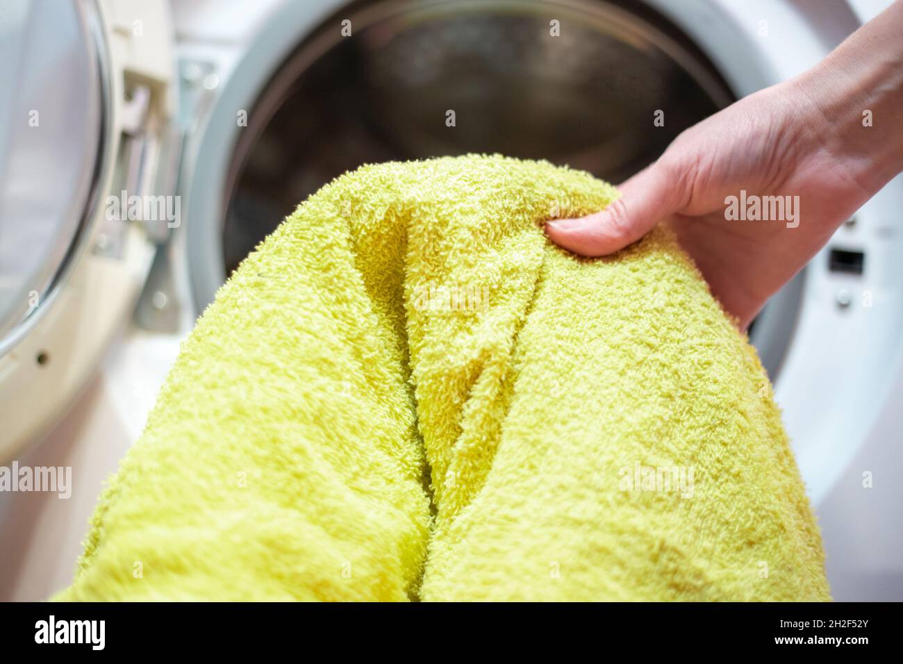 loading dirty laundry into a washing machine Stock Photo - Alamy