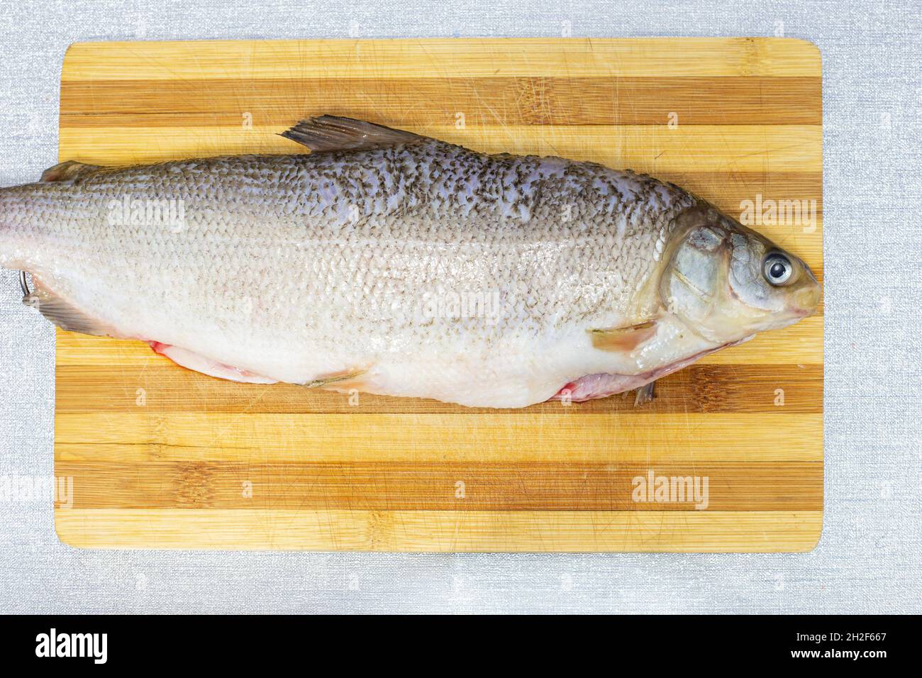 cooking fish cheeks in the kitchen, raw product on a cutting wooden ...