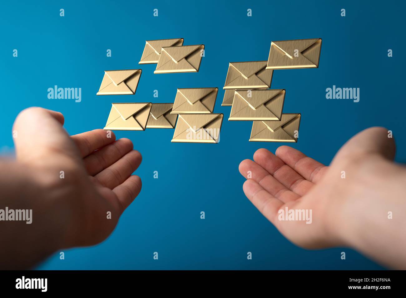 Male's hands holding illustrated email inboxes isolated on a blue ...