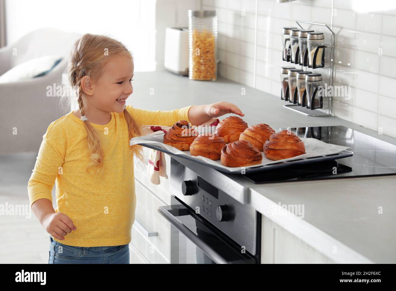 Little girl with tray of oven baked buns in kitchen Stock Photo - Alamy