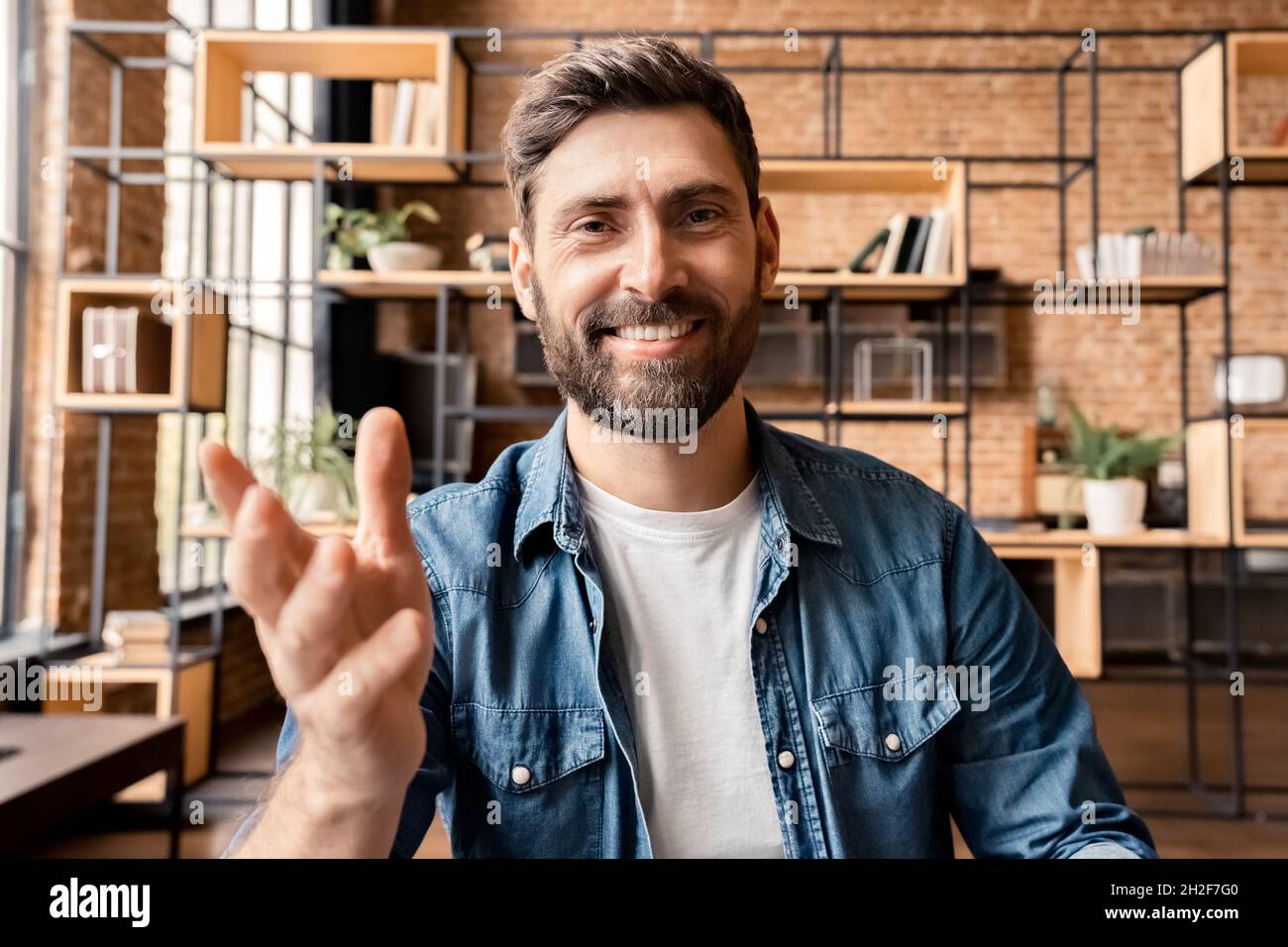 Businessman making video call, looking at camera, gesturing and talking ...