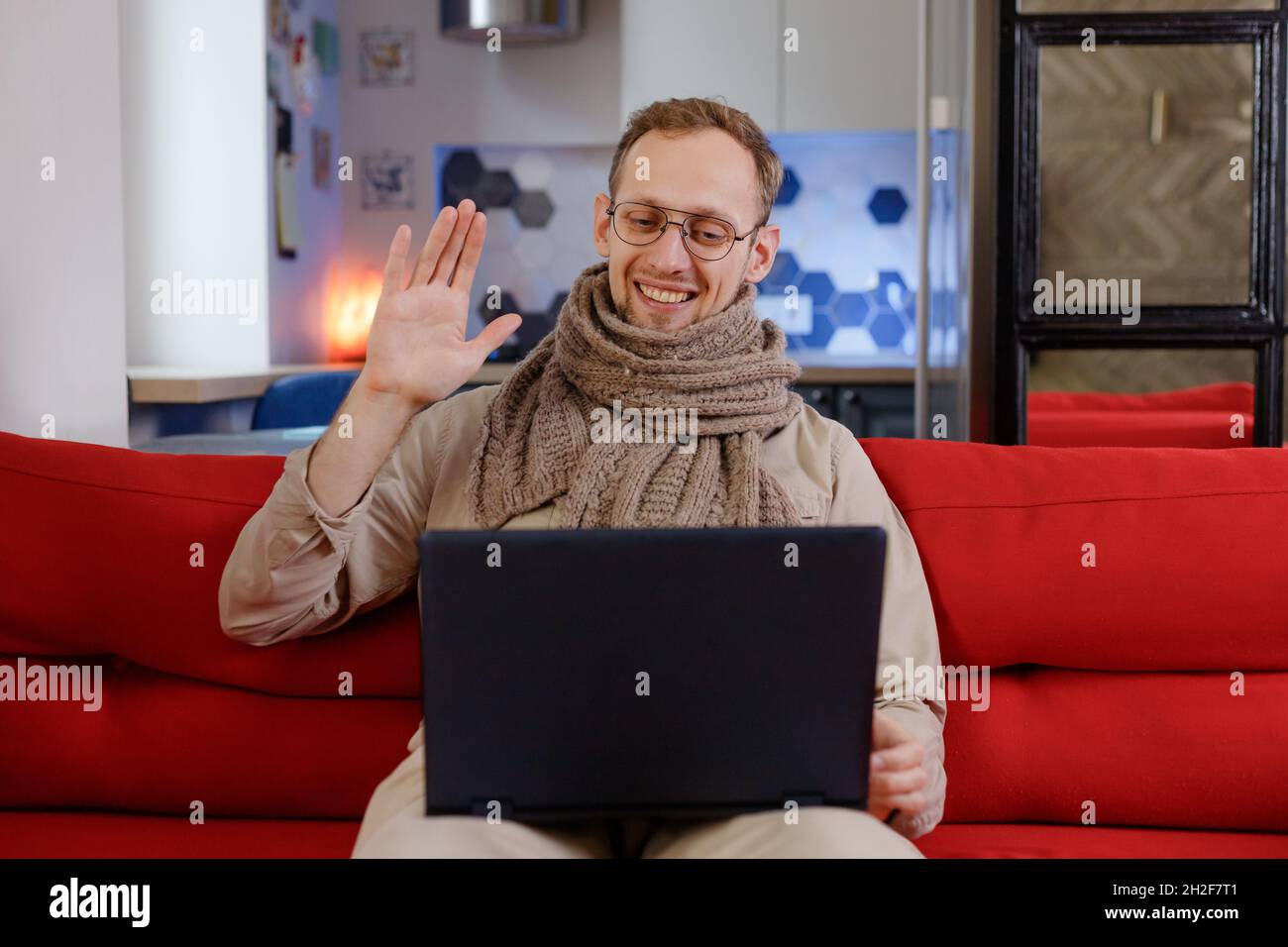 Happy man waving hand using laptop computer having video conference ...
