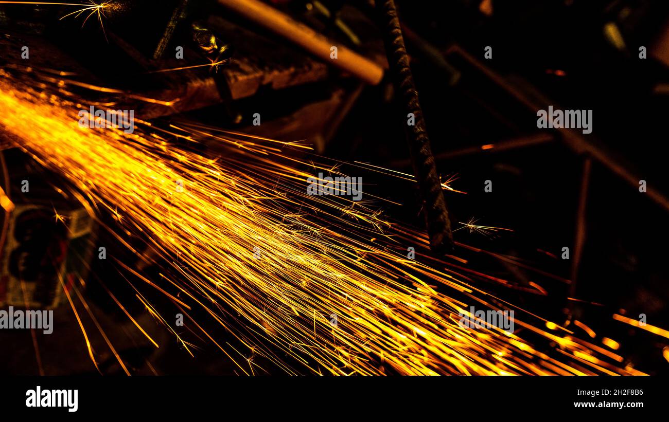 incandescent metal filings coming out of a killing cutting machine ...