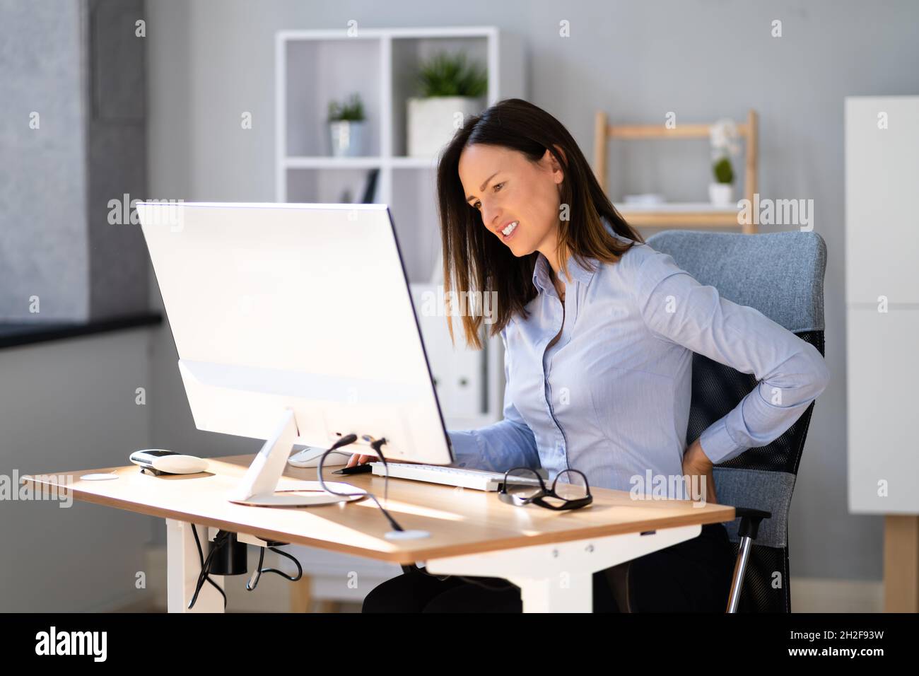 Back Pain Bad Posture Woman Sitting In Office Stock Photo - Alamy