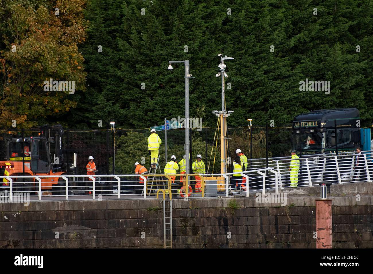 Workmen installing security fence barrier cop26 hi-res stock ...