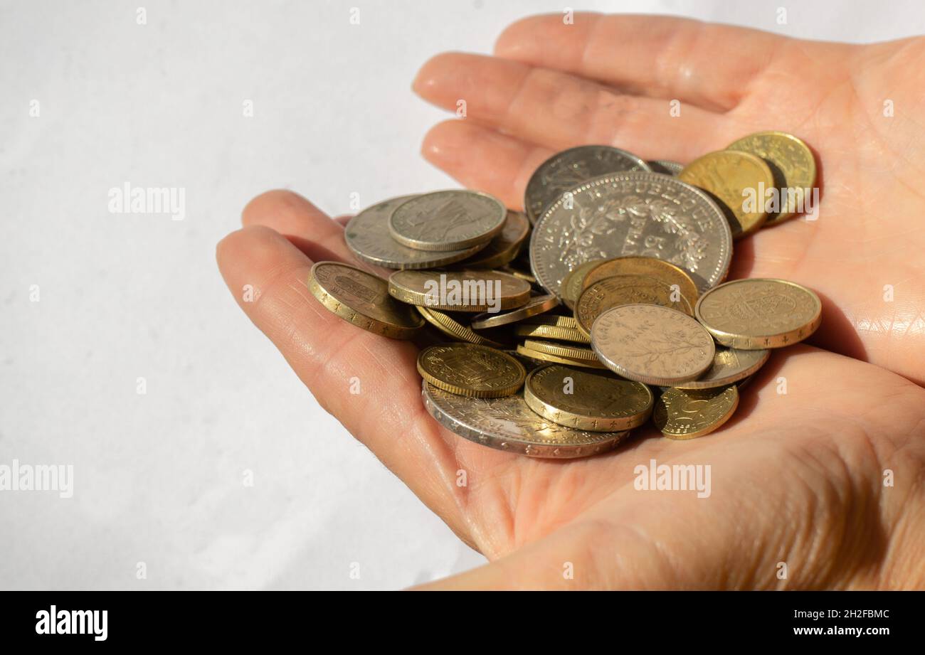 bowl-shaped hands holding a handful of coins of different colors and ...
