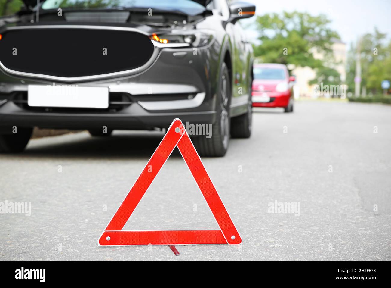 Emergency stop sign near broken car on road Stock Photo - Alamy