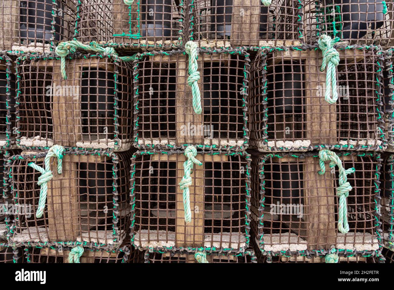 Close up of Lobster and crab fish pots netted boxes stacked in harbour ...