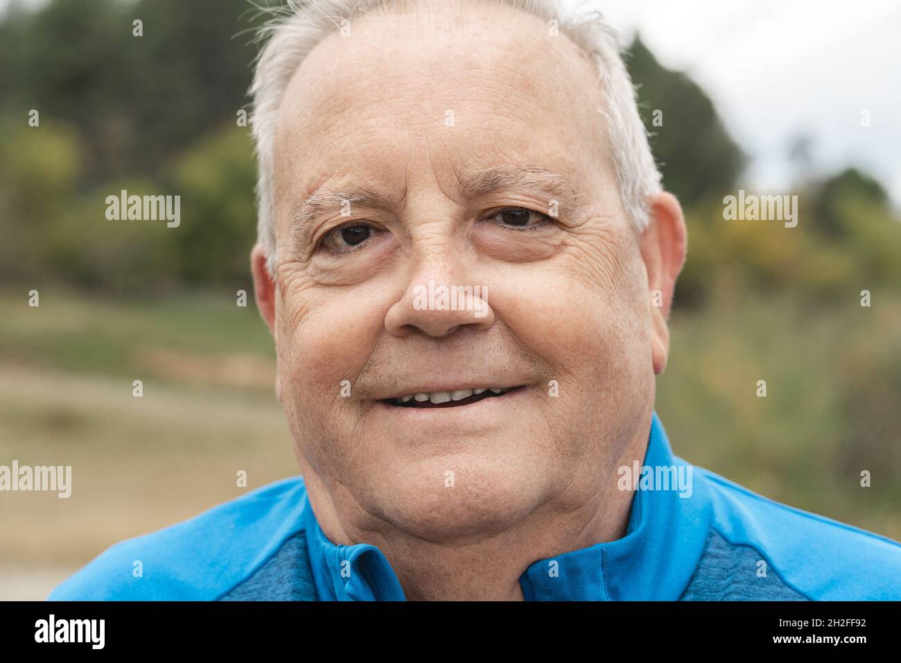 Happy senior man smiling on camera outdoor in the woods - Elderly ...