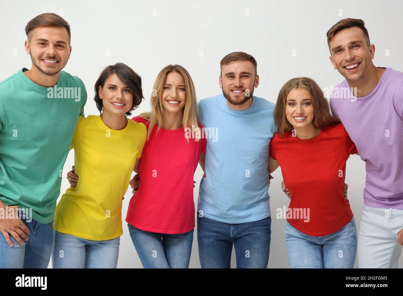 Group of young people hugging each other on light background. Unity ...