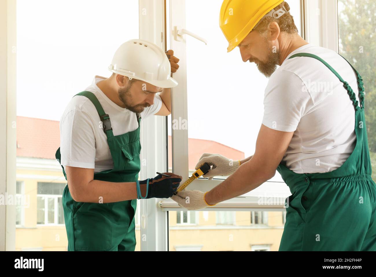 Construction workers installing new window in house Stock Photo - Alamy