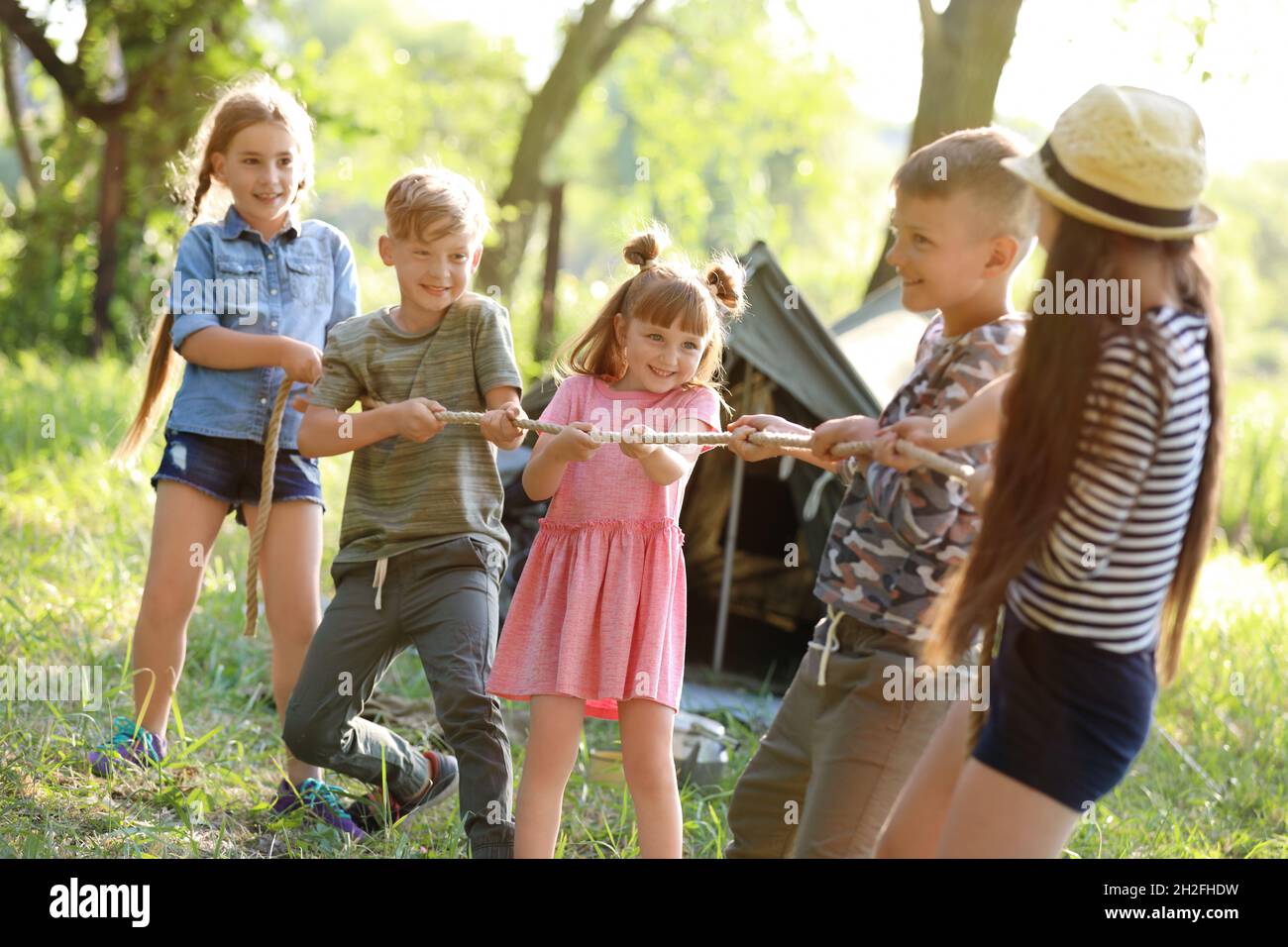 Little children pulling rope outdoors. Summer camp Stock Photo - Alamy