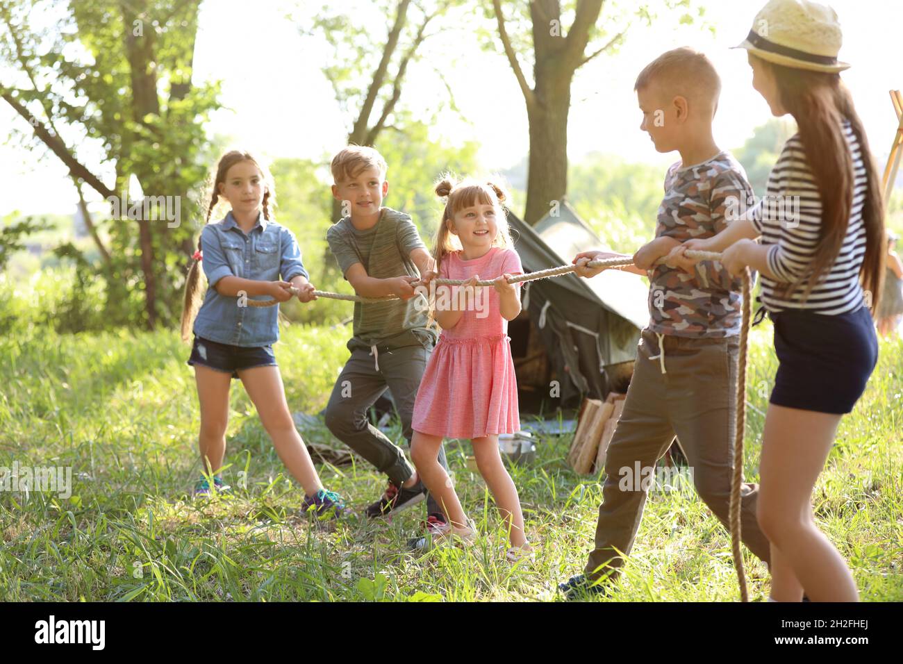 Little children pulling rope outdoors. Summer camp Stock Photo - Alamy