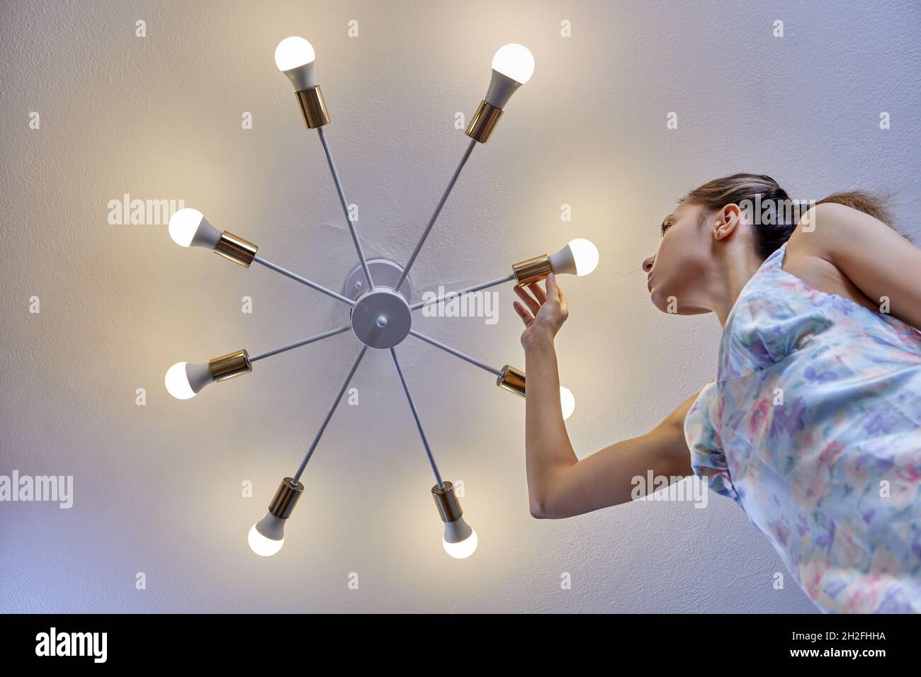 Replacing light bulb in LED lamp by woman indoors Stock Photo - Alamy