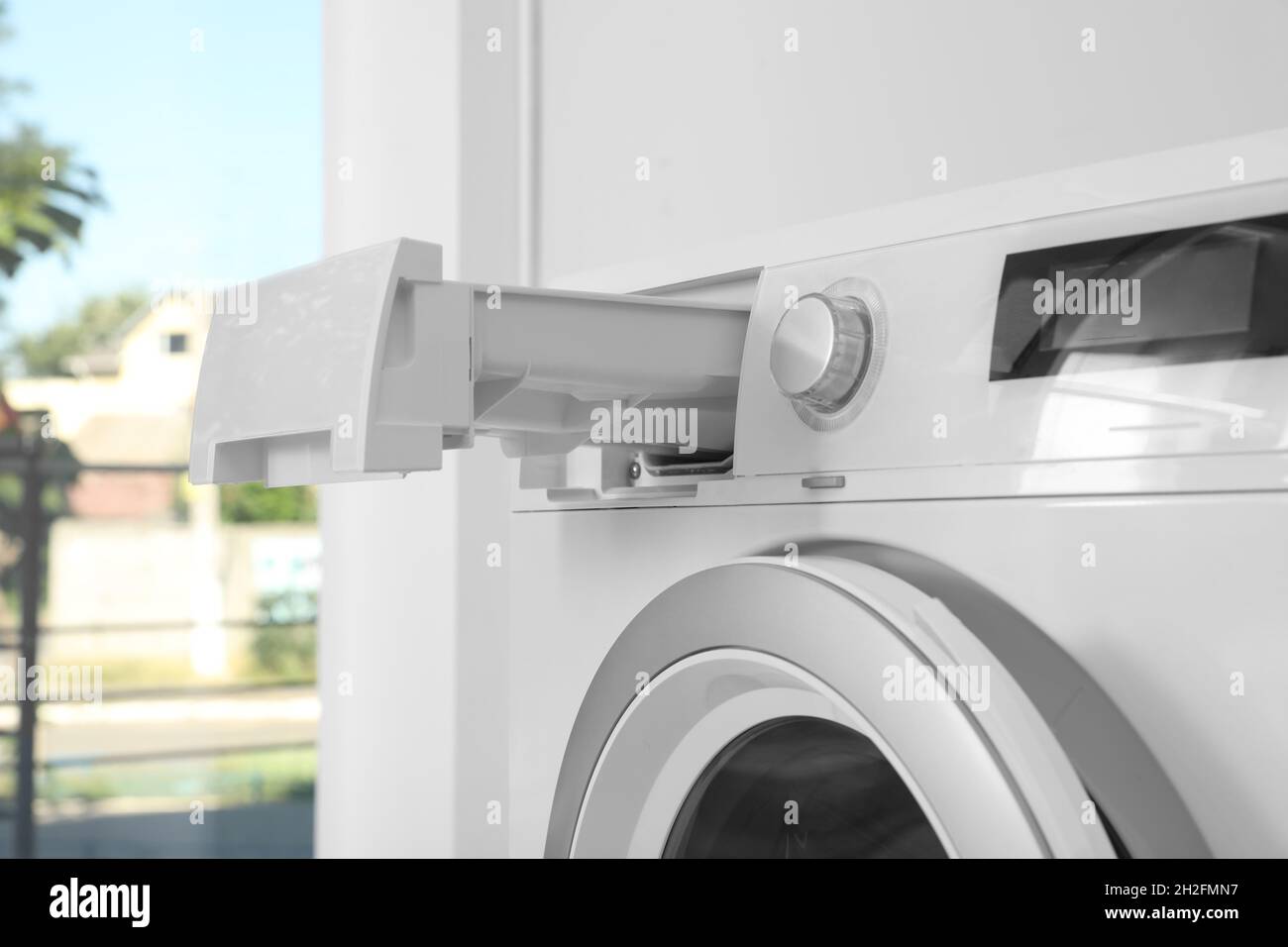 Washing machine with open detergent drawer in laundry room, closeup ...
