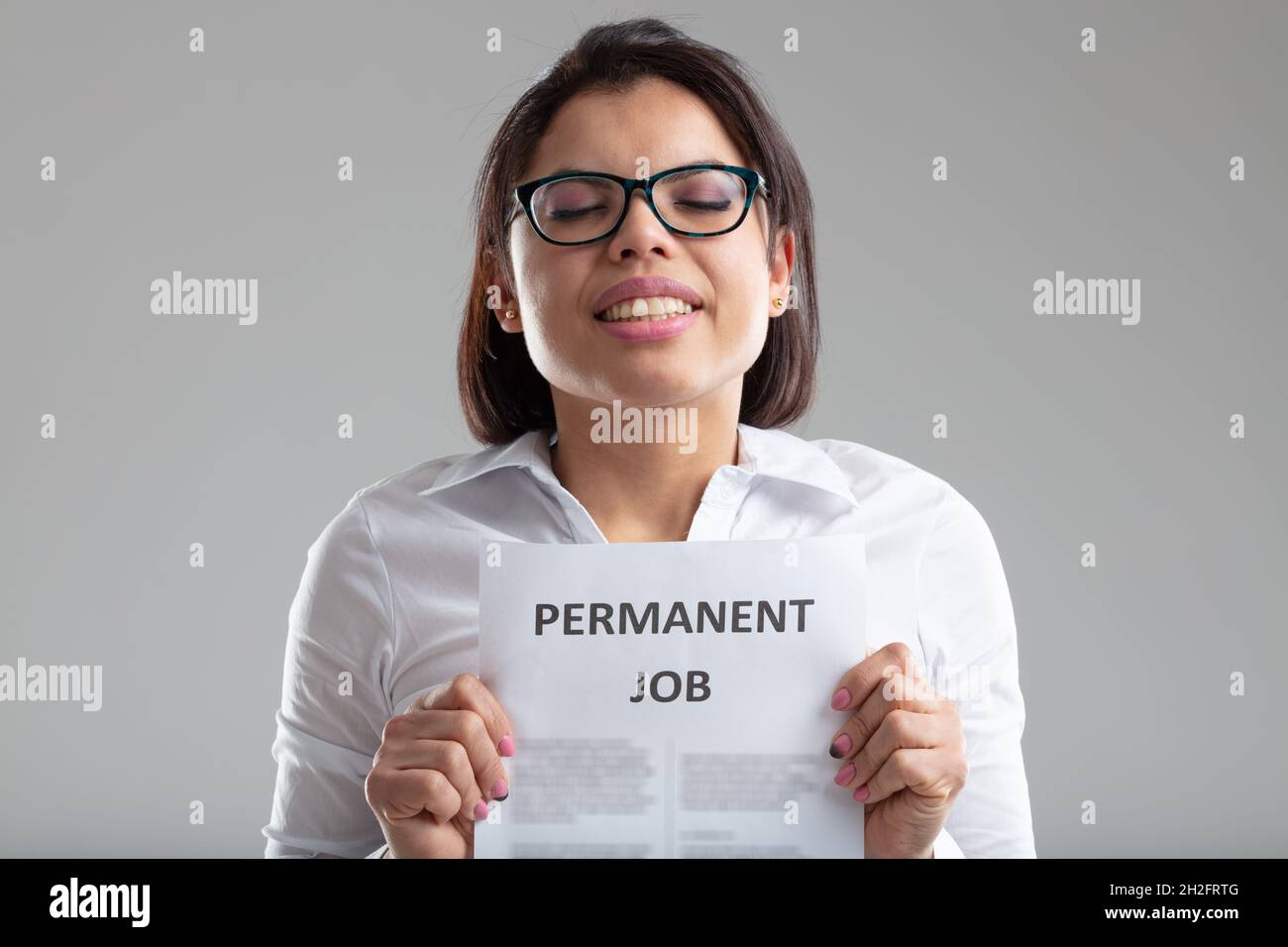 Happy young woman holding up a sign - Permanent Job - with contract of ...