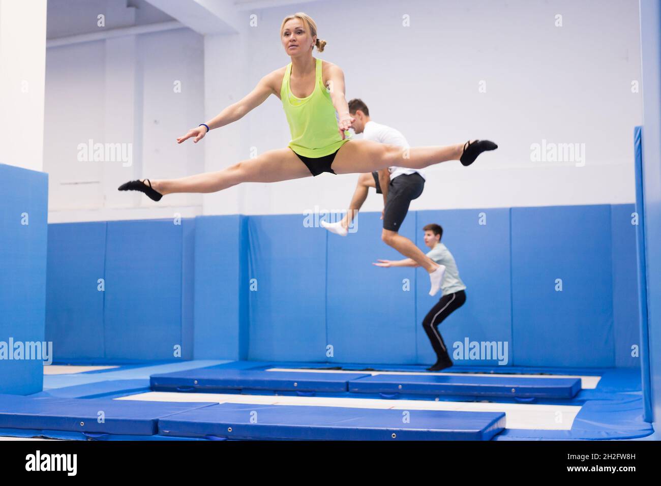 Woman practicing side split on trampoline Stock Photo - Alamy