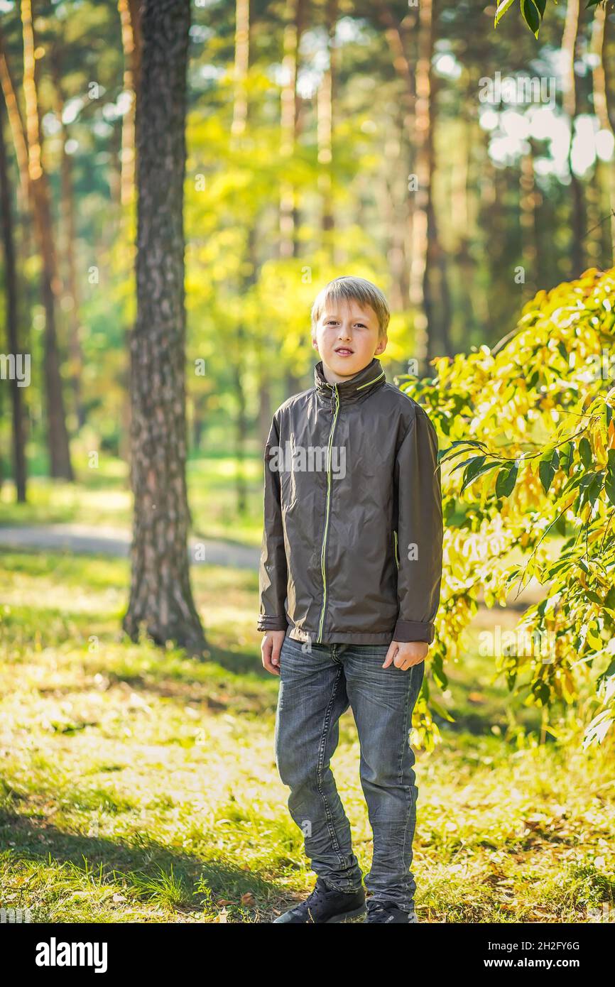 Teenager laughs opening his teeth in a city park against the backdrop ...