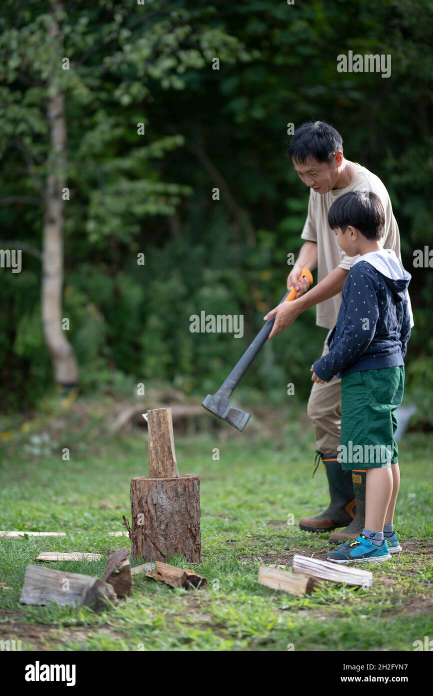 Father Teaches Wood Chopping to His Son Stock Photo - Alamy