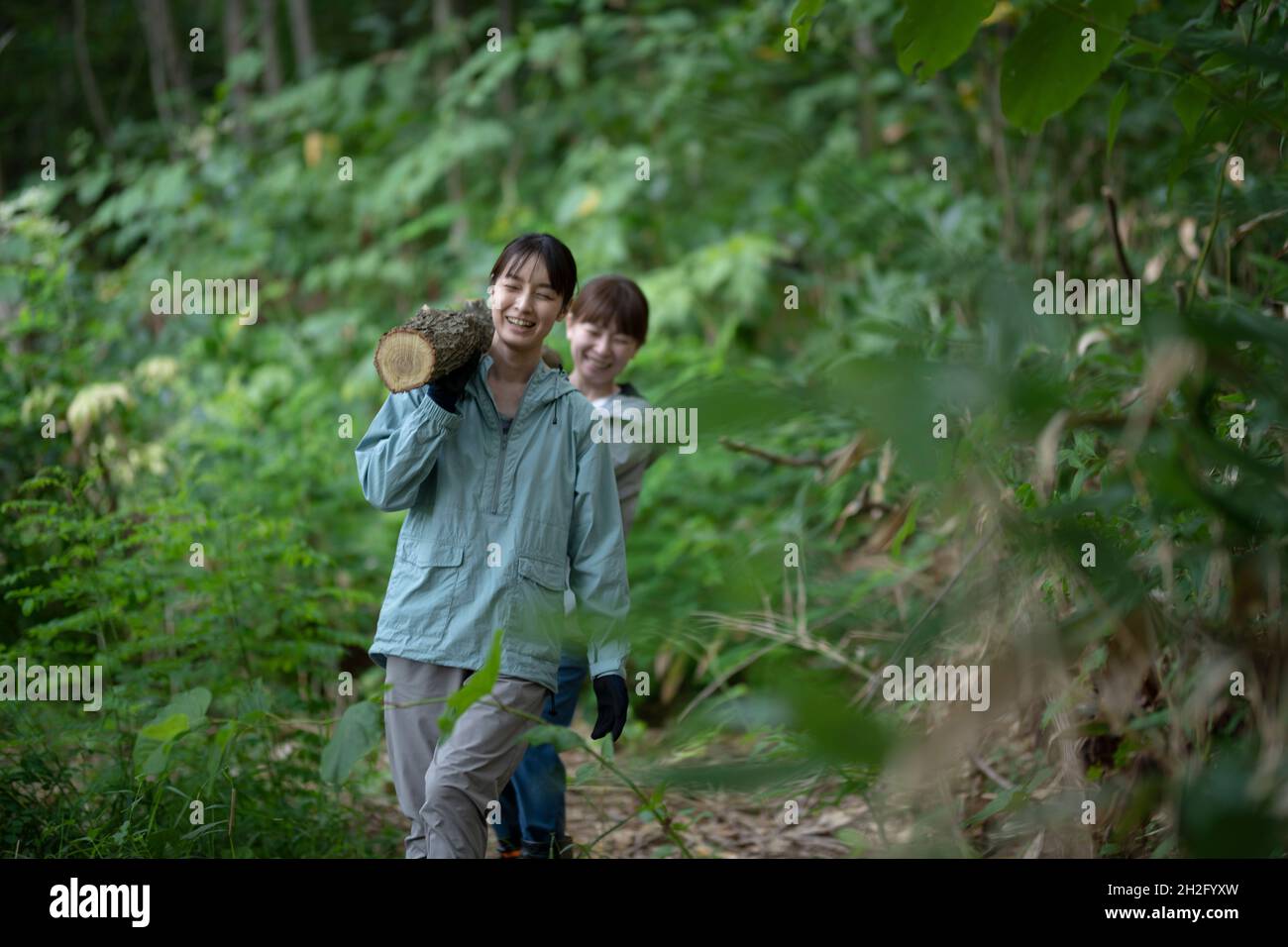Women Carrying Log Stock Photo - Alamy