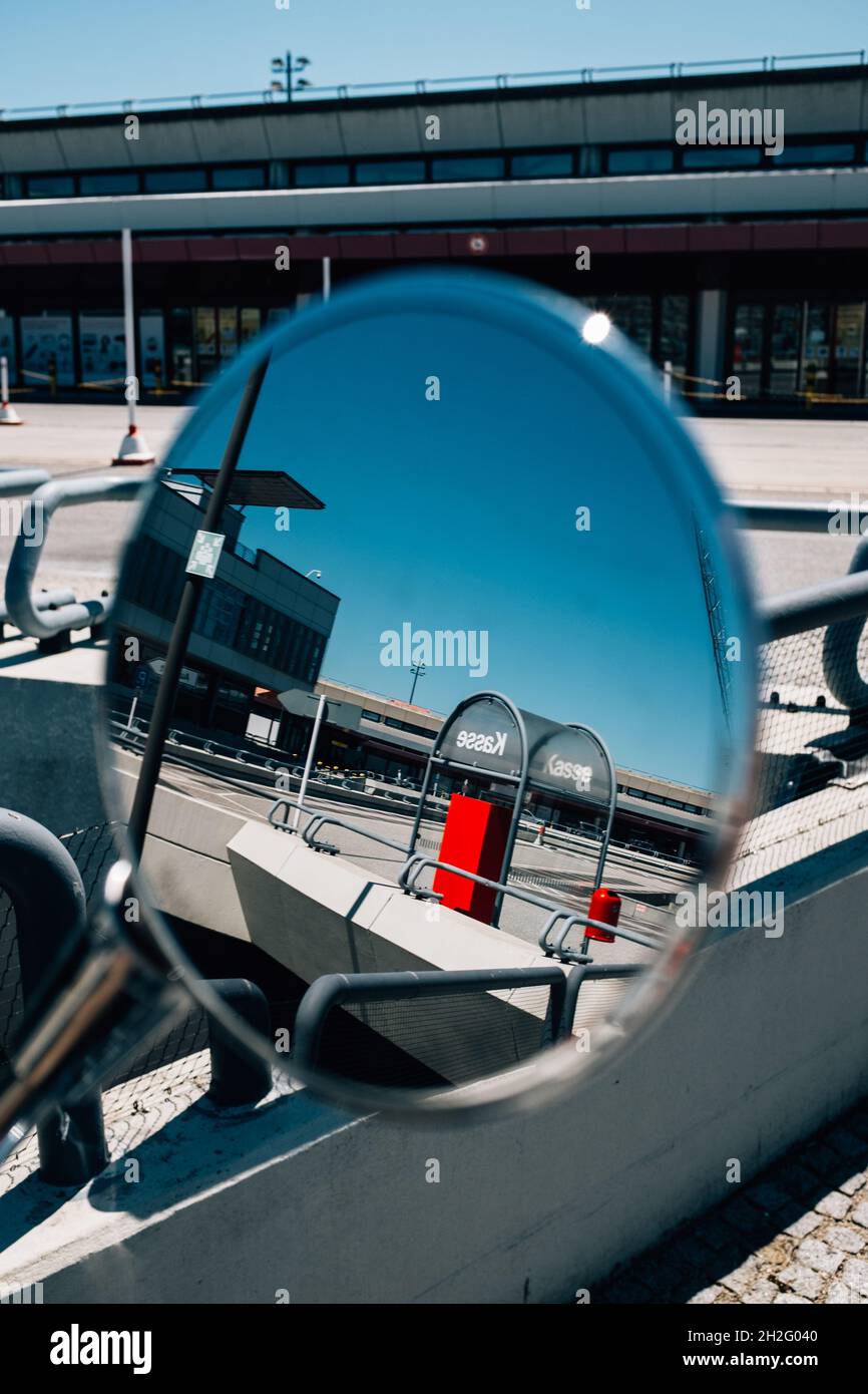 Vertical view of a round mirror reflecting cityscape under the blue ...