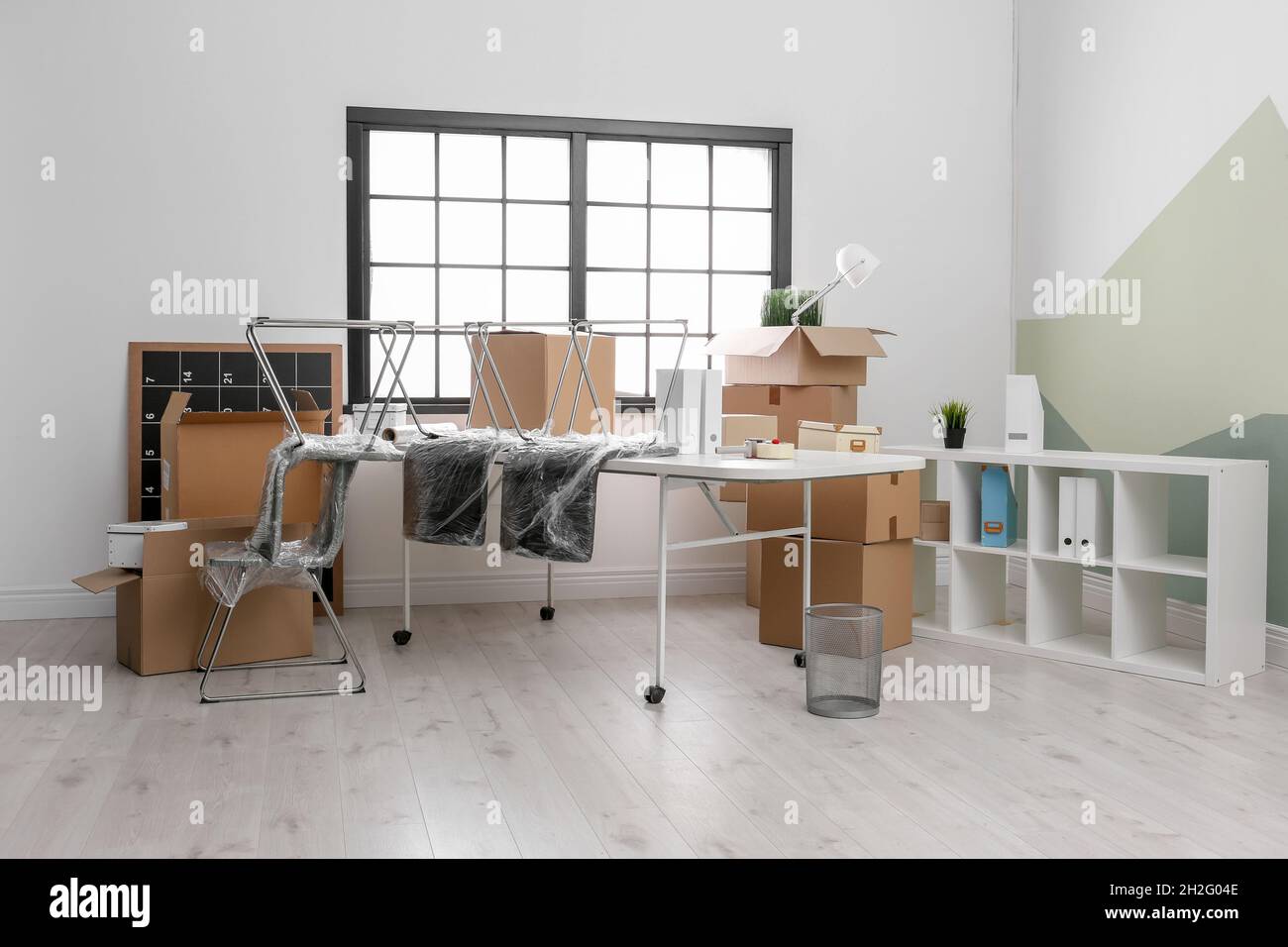 Moving boxes and furniture in new office Stock Photo - Alamy