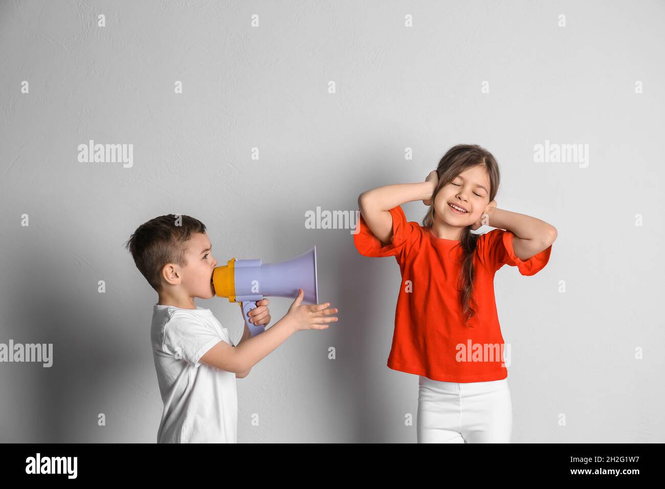 Adorable little kids with megaphone on light background Stock Photo - Alamy
