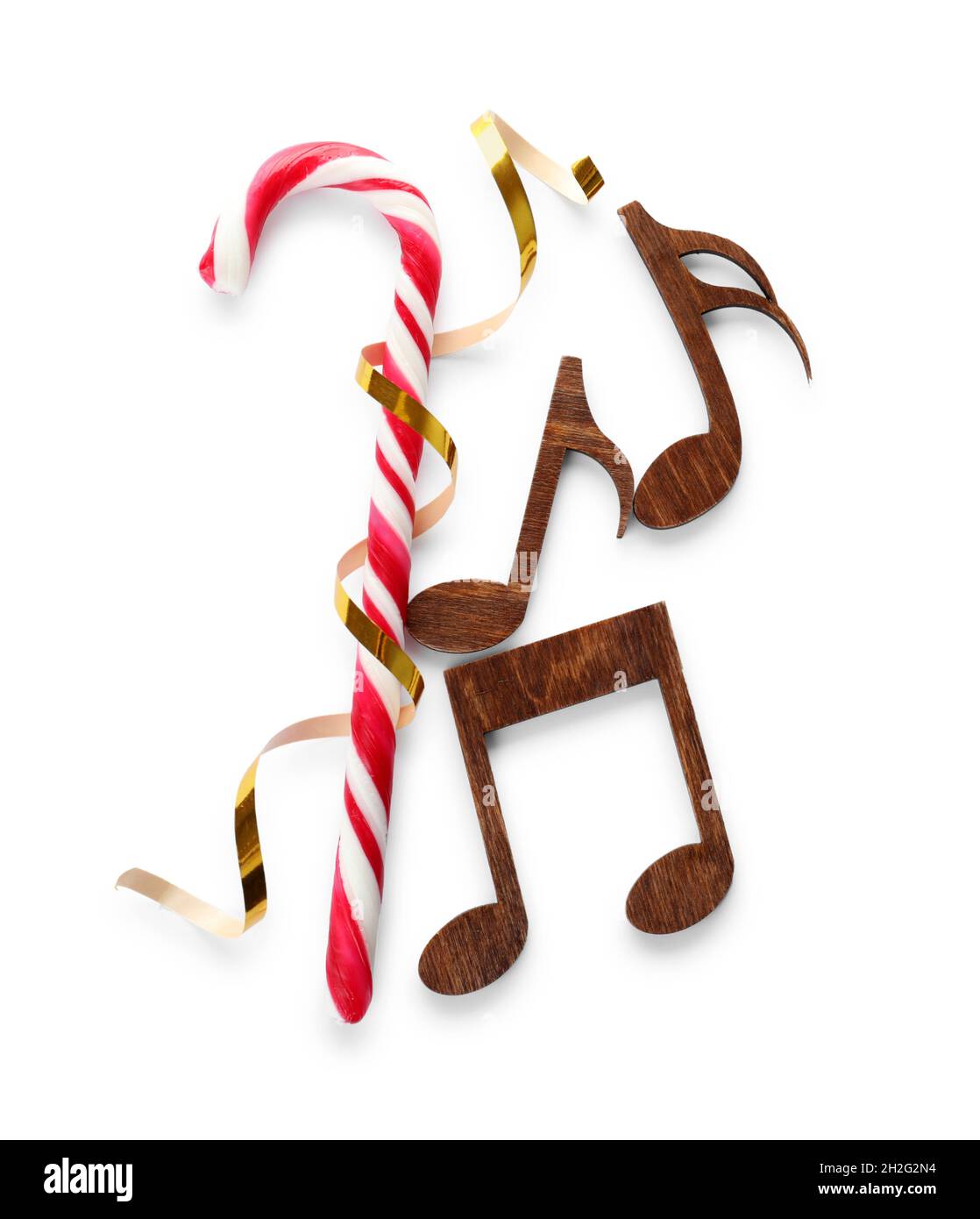 Composition with wooden music notes and candy cane on white background ...