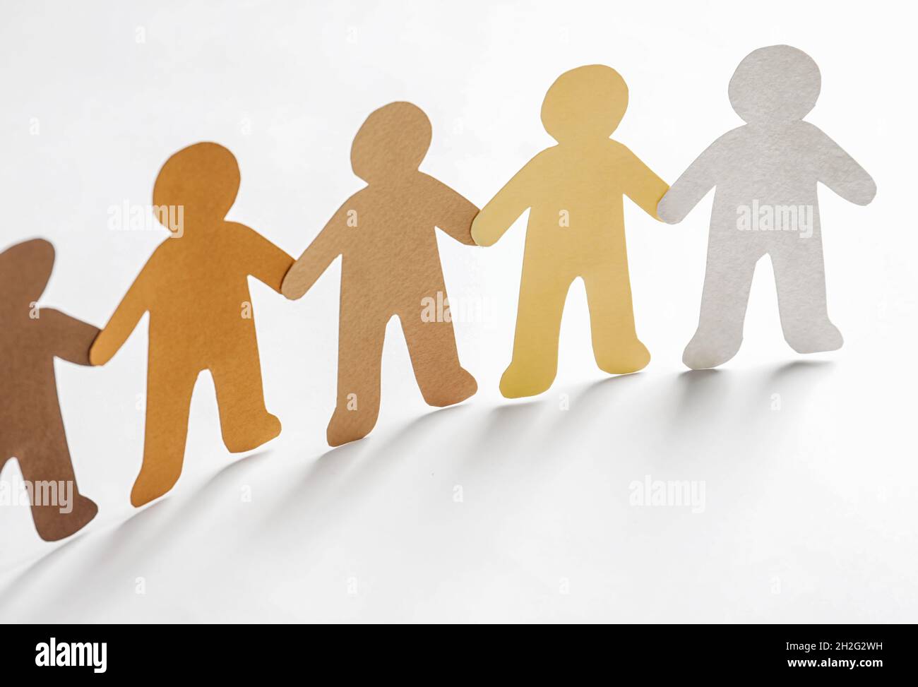 Paper people holding hands on light background. Unity concept Stock ...