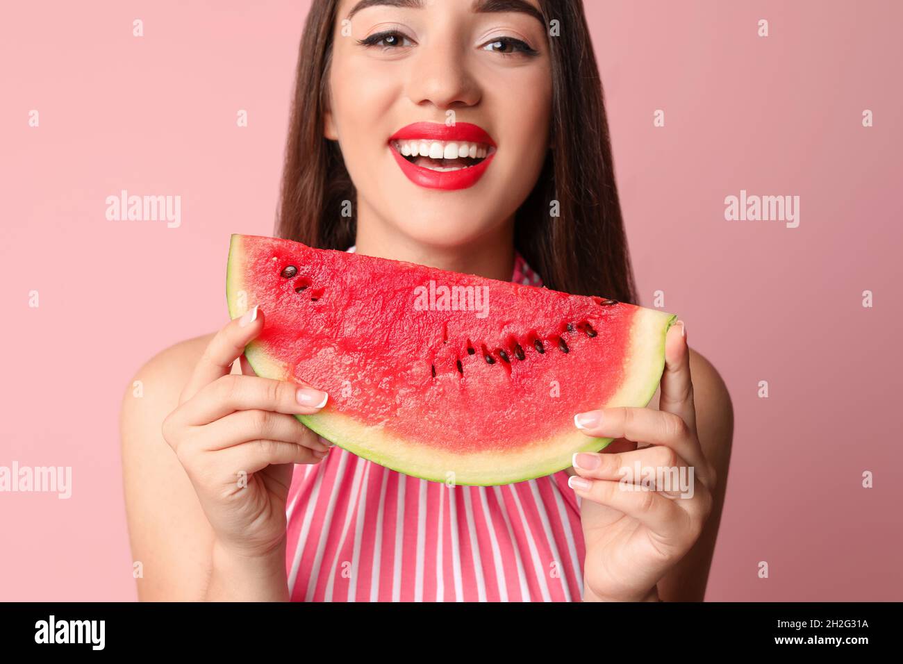 Beautiful young woman posing with watermelon on color background Stock ...