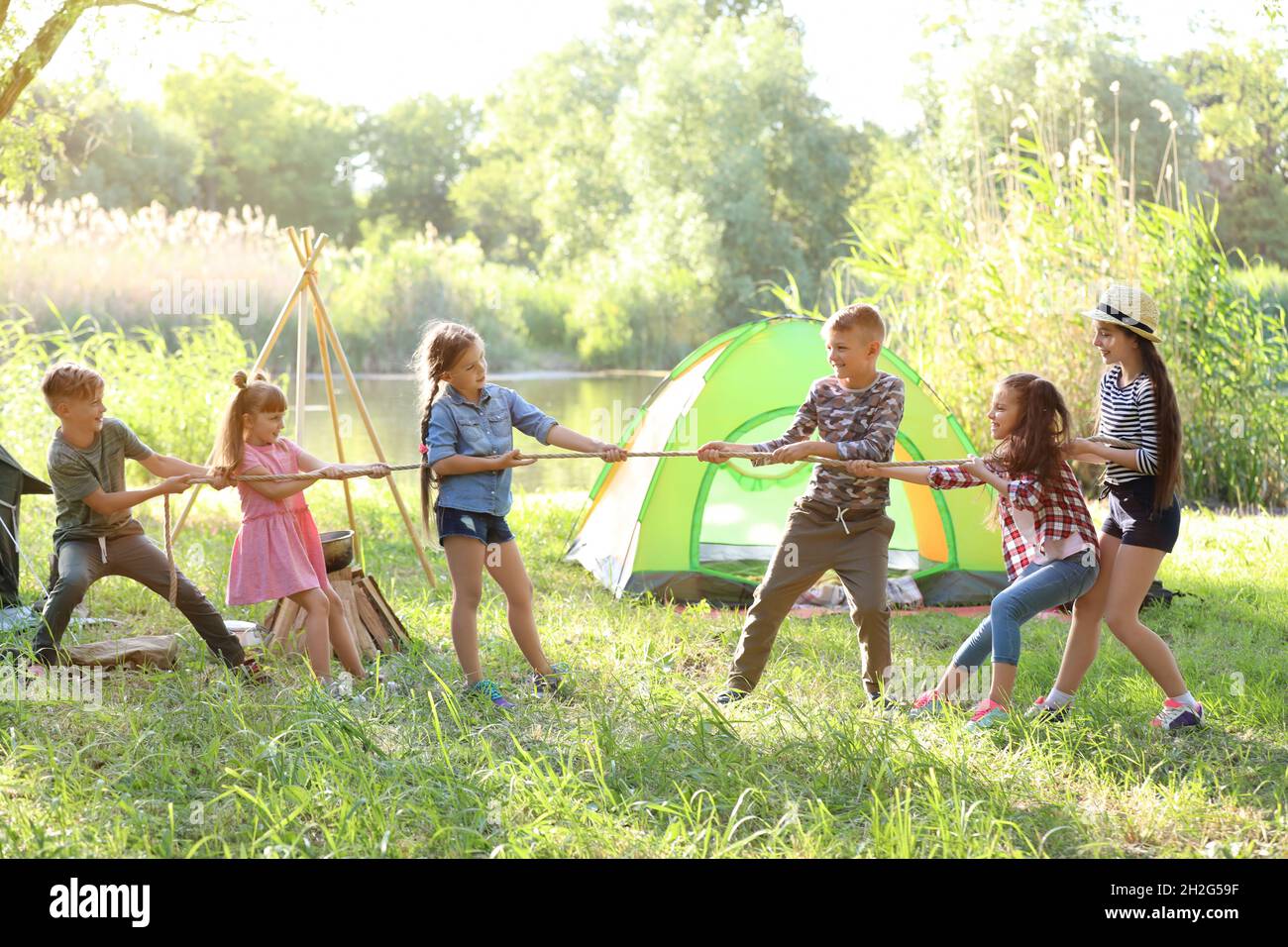 Little children pulling rope outdoors. Summer camp Stock Photo - Alamy