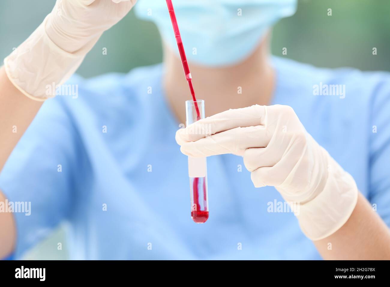 Scientist dripping blood into test tube in laboratory Stock Photo - Alamy