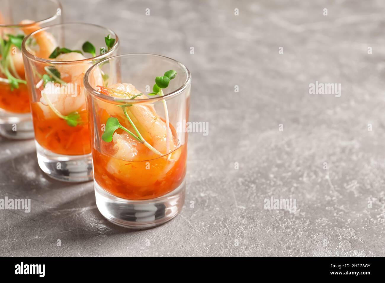 Delicious shrimp cocktail shots on grey table Stock Photo - Alamy