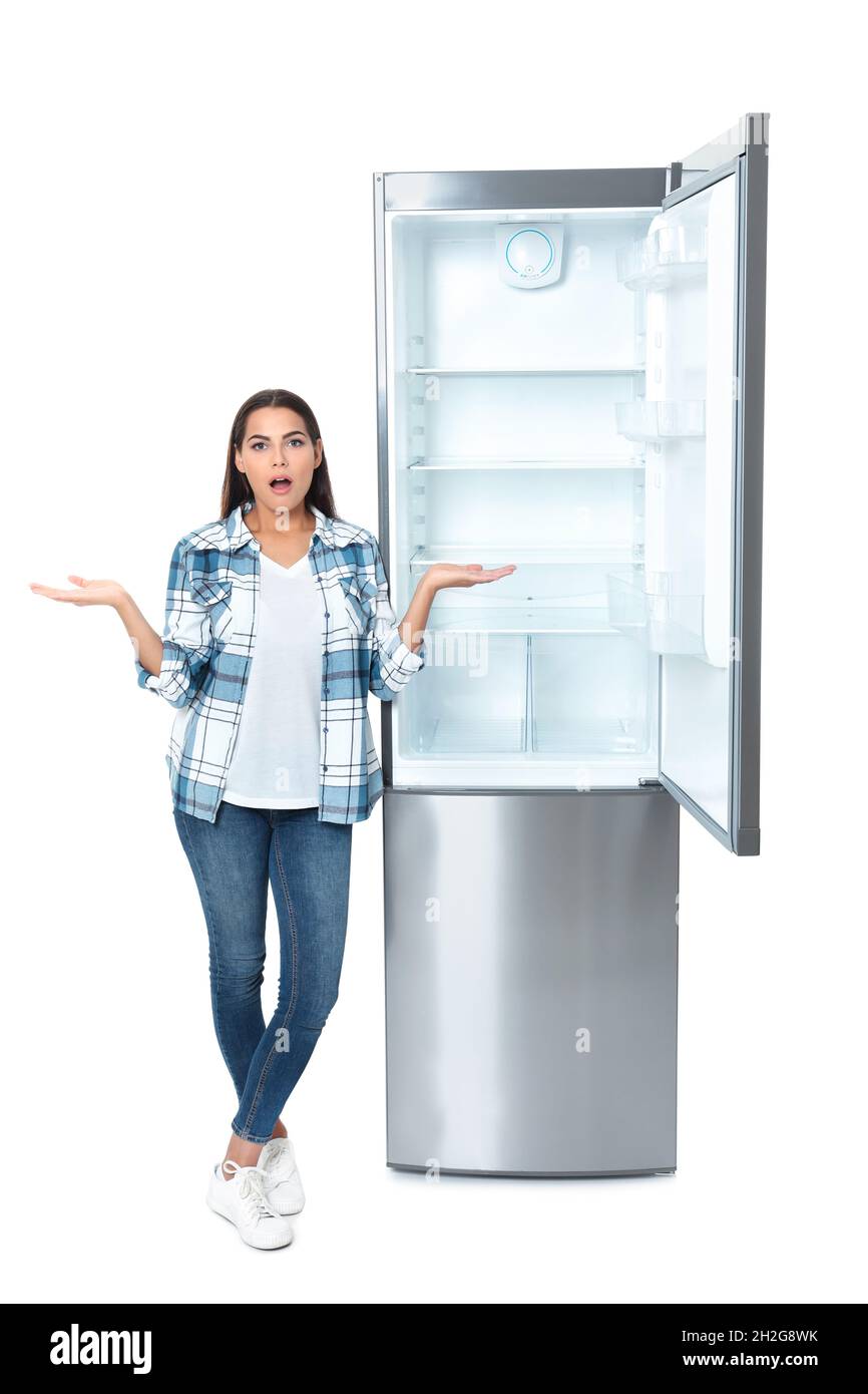 Emotional woman near empty refrigerator on white background Stock Photo ...