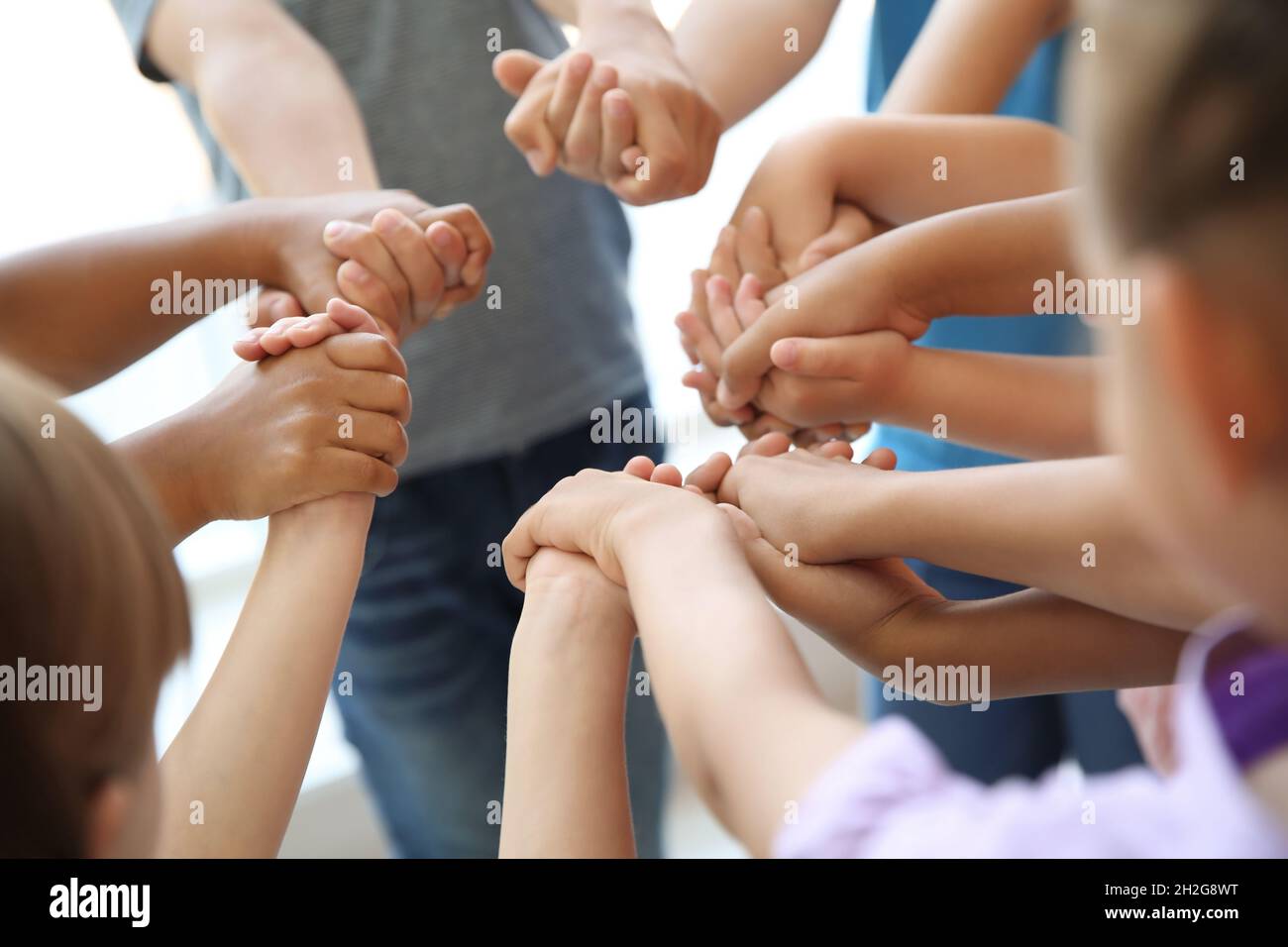 Little children holding their hands together, closeup. Unity concept ...