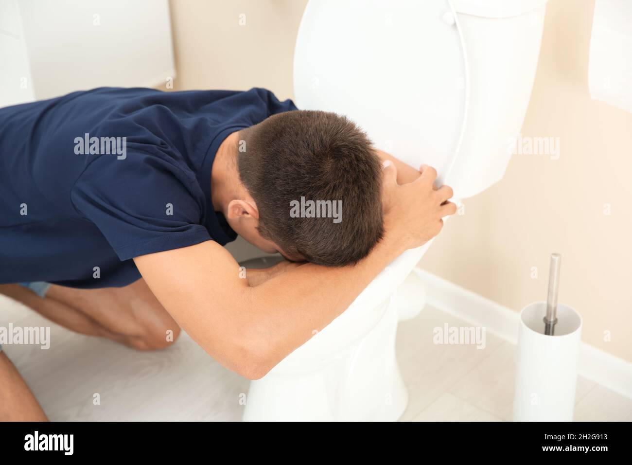 Man vomiting in toilet bowl hi-res stock photography and images - Alamy