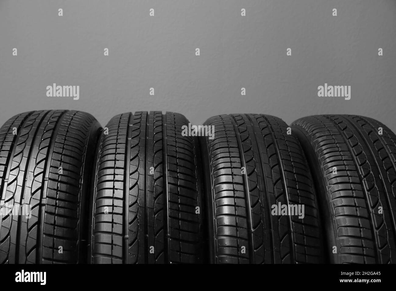 Car tires on grey background, closeup Stock Photo - Alamy