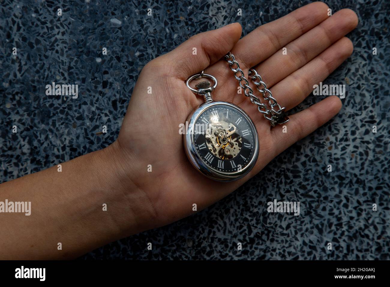 A retro pocket watch with chain in the palm of the girl's hand. Wall ...