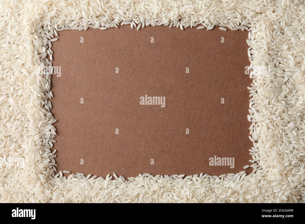 Frame made with long grain rice on color background, top view. Space ...