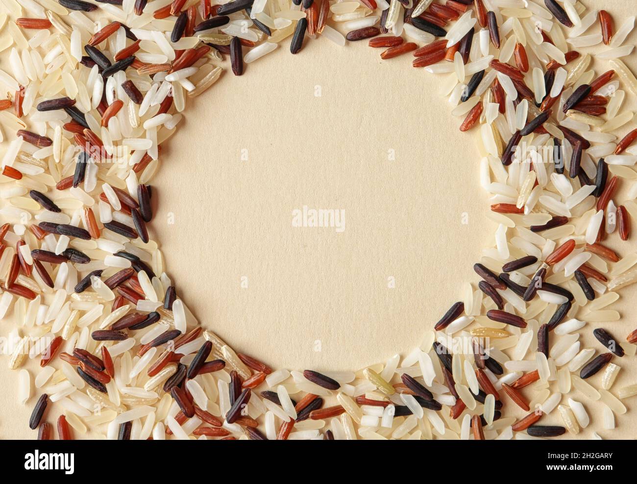 Round frame made with mixed brown and other types of rice on color ...