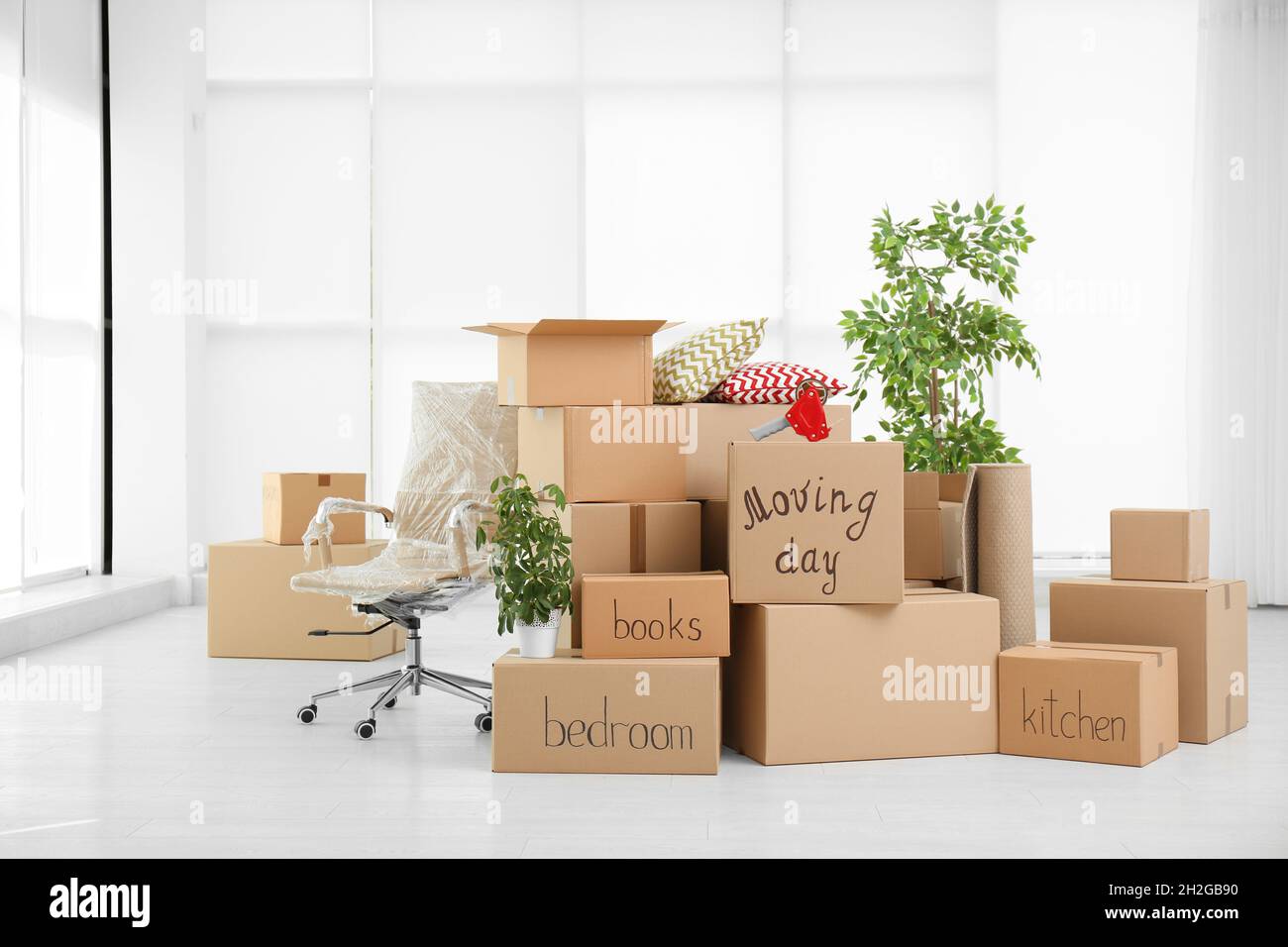 Pile of moving boxes in empty room Stock Photo - Alamy