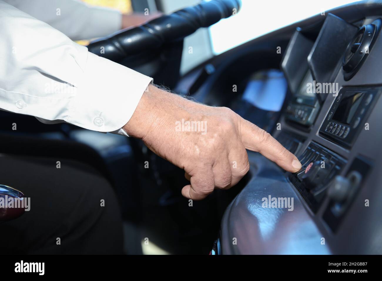 Professional bus driver pushing button on dashboard. Passenger ...