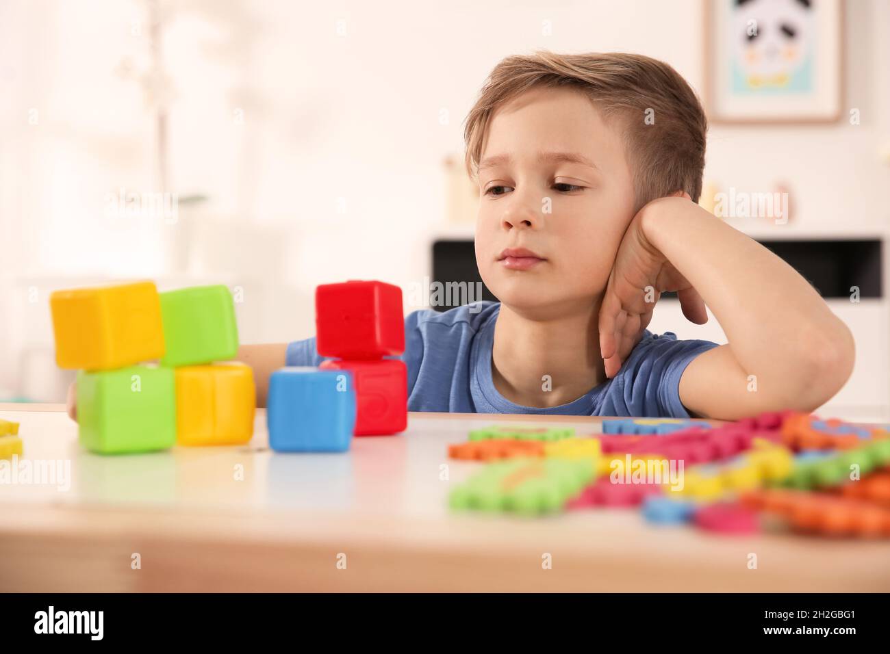 Little autistic boy playing with cubes at home Stock Photo - Alamy