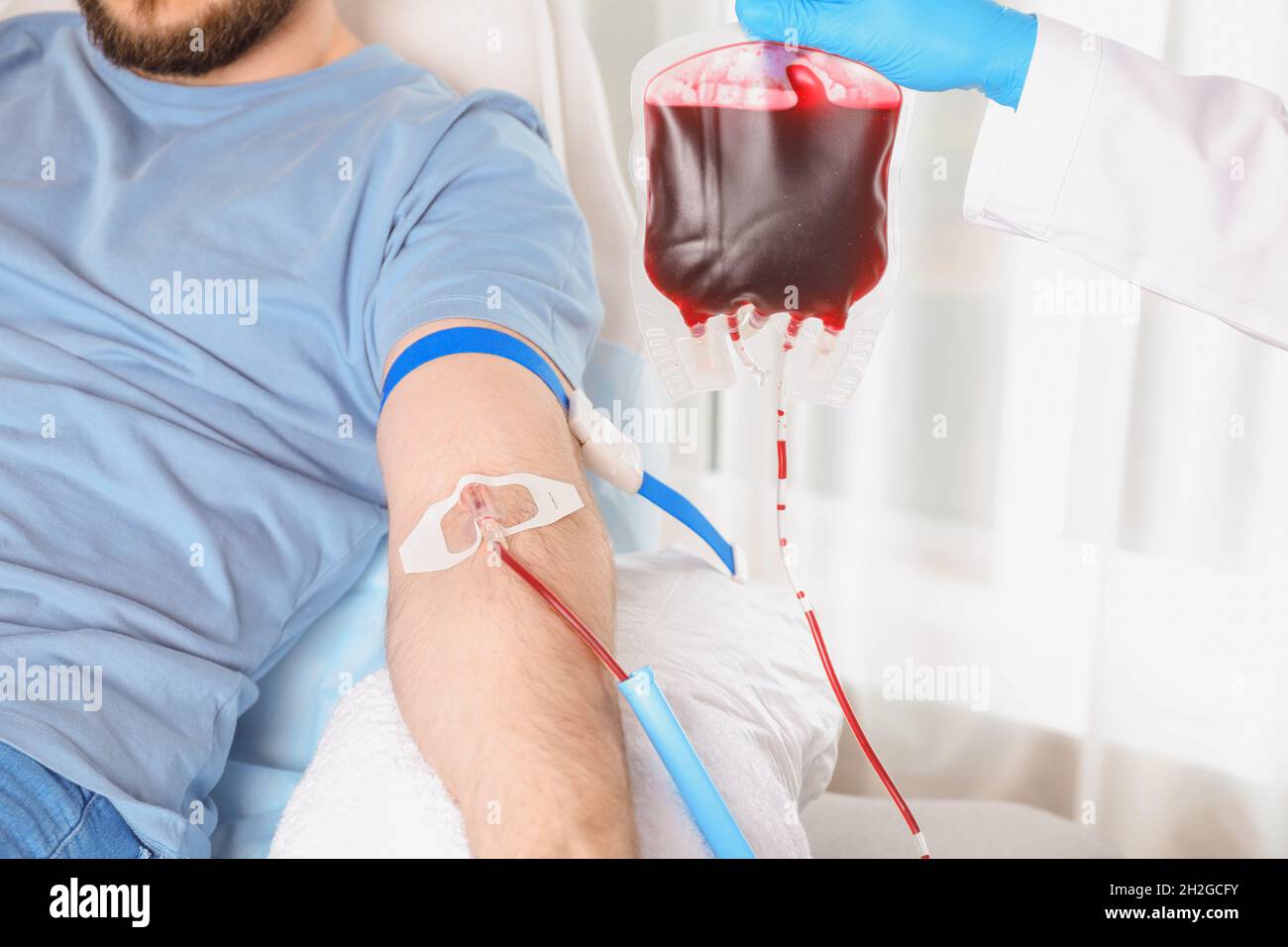Man donating blood to save someone's life in hospital Stock Photo - Alamy