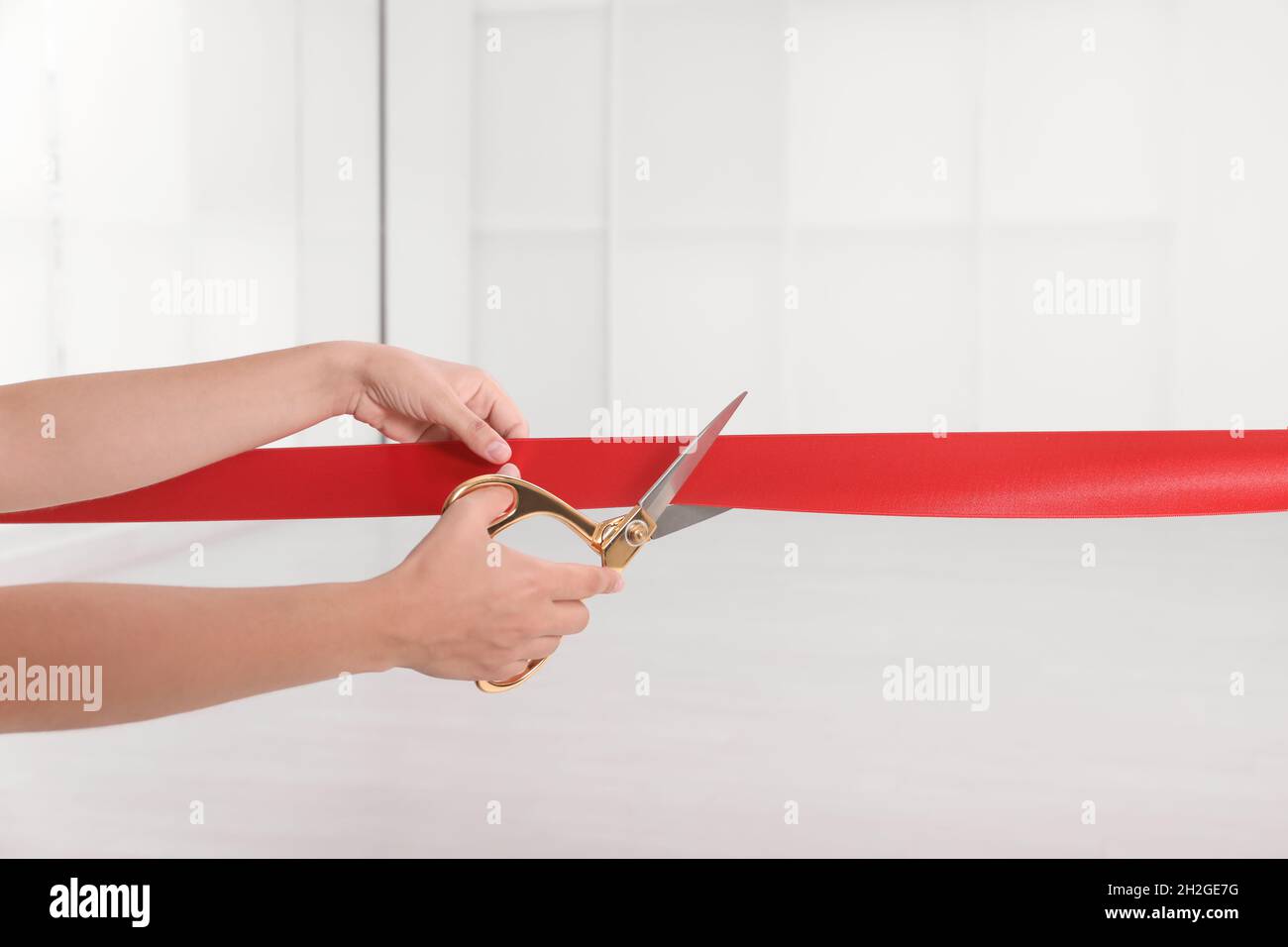 Woman cutting red ribbon on blurred background. Festive ceremony Stock ...