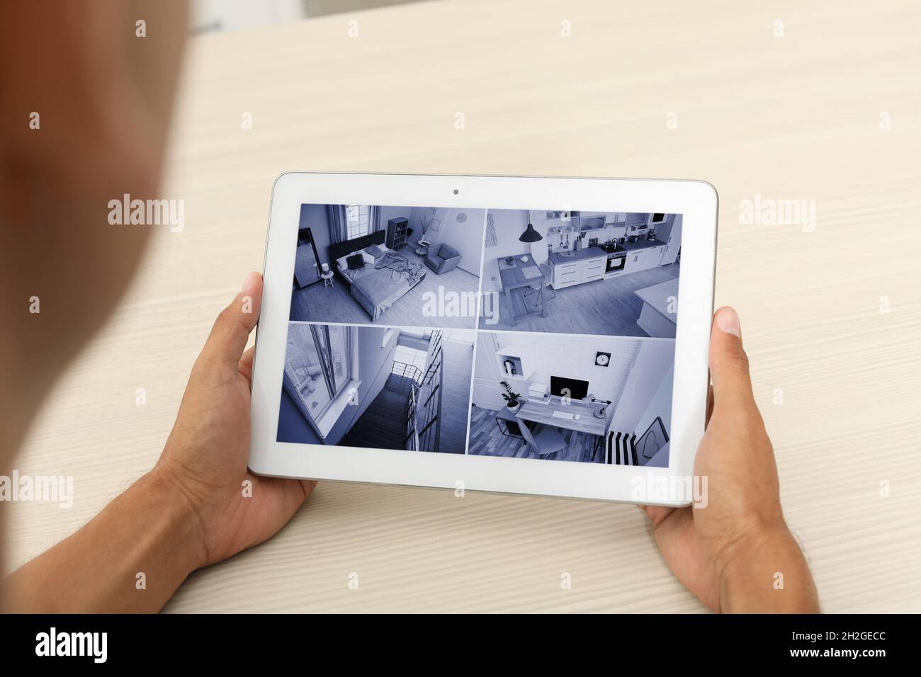 Man using tablet for monitoring CCTV cameras at table. Home security ...