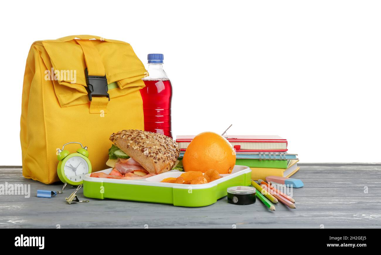 Composition with lunch box and food on table against white background ...