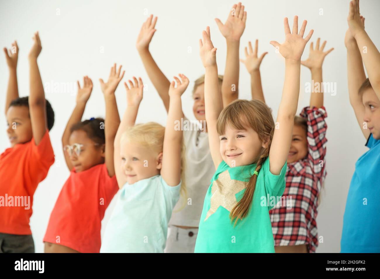 Little children raising hands together on light background. Unity ...
